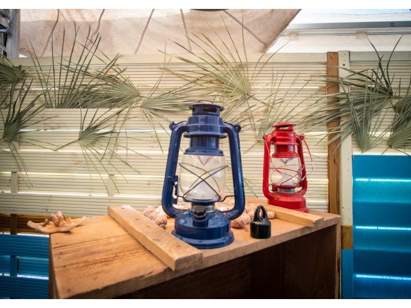 Naos location loue lampe tempête rouge pour décor à thème Far West.